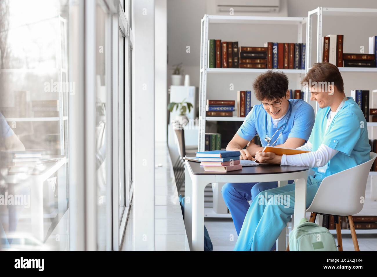 Male medical interns studying at table in library Stock Photo - Alamy