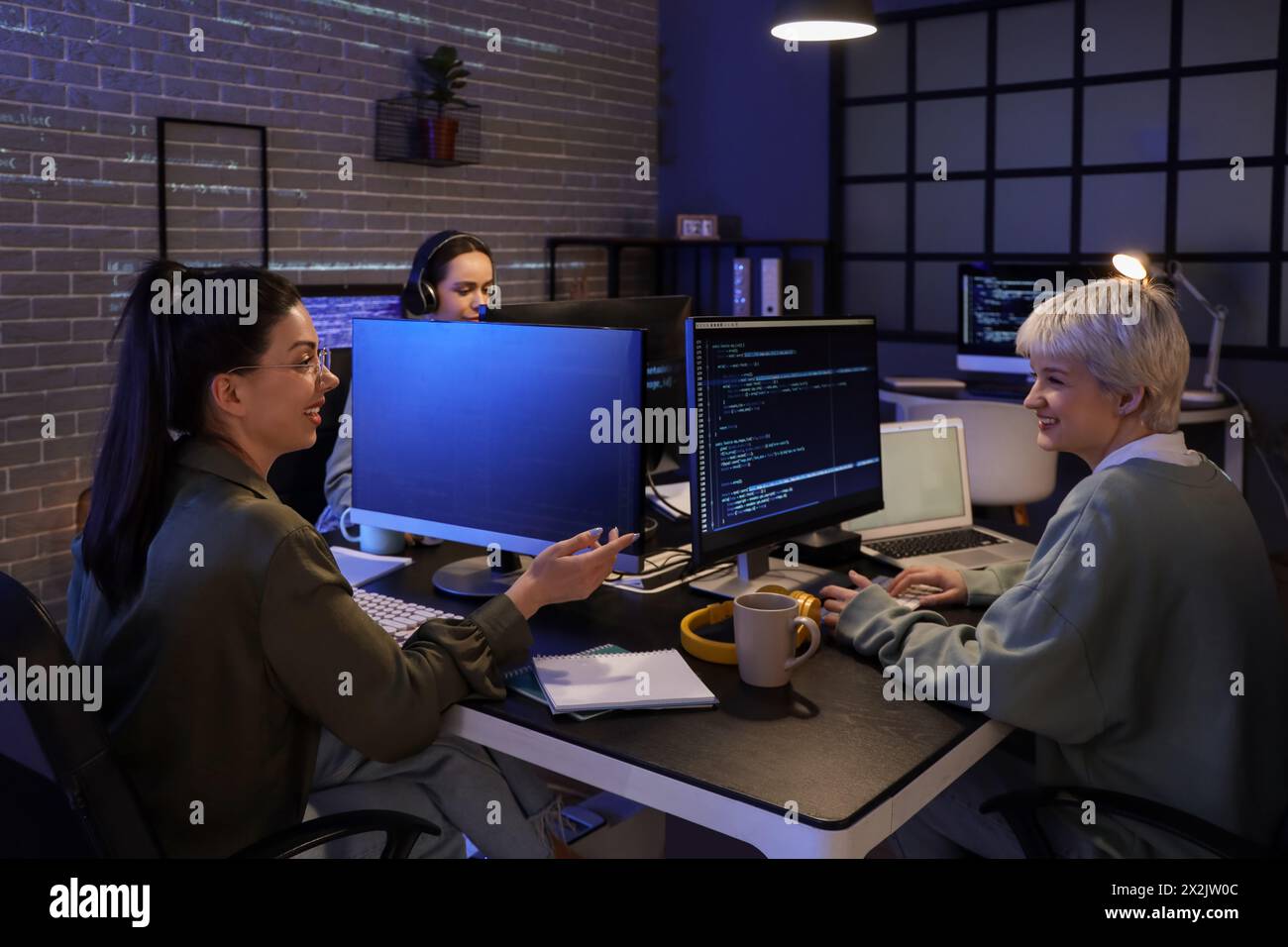 Group of female programmers working in office at night Stock Photo - Alamy