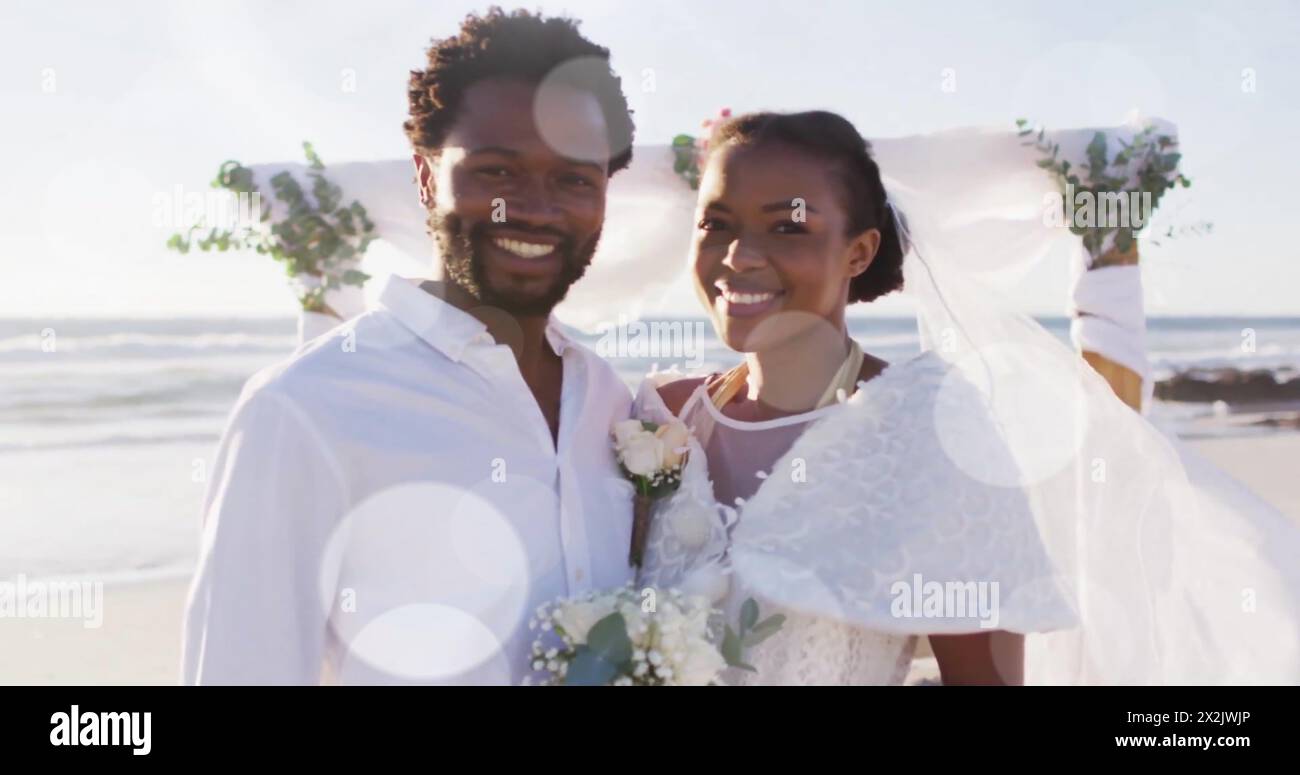 Image of light spots over happy african american bride and groom ...