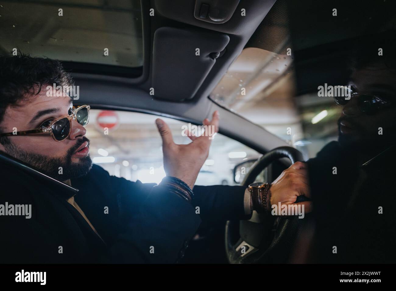 Two men engaging in a serious conversation inside a car Stock Photo - Alamy