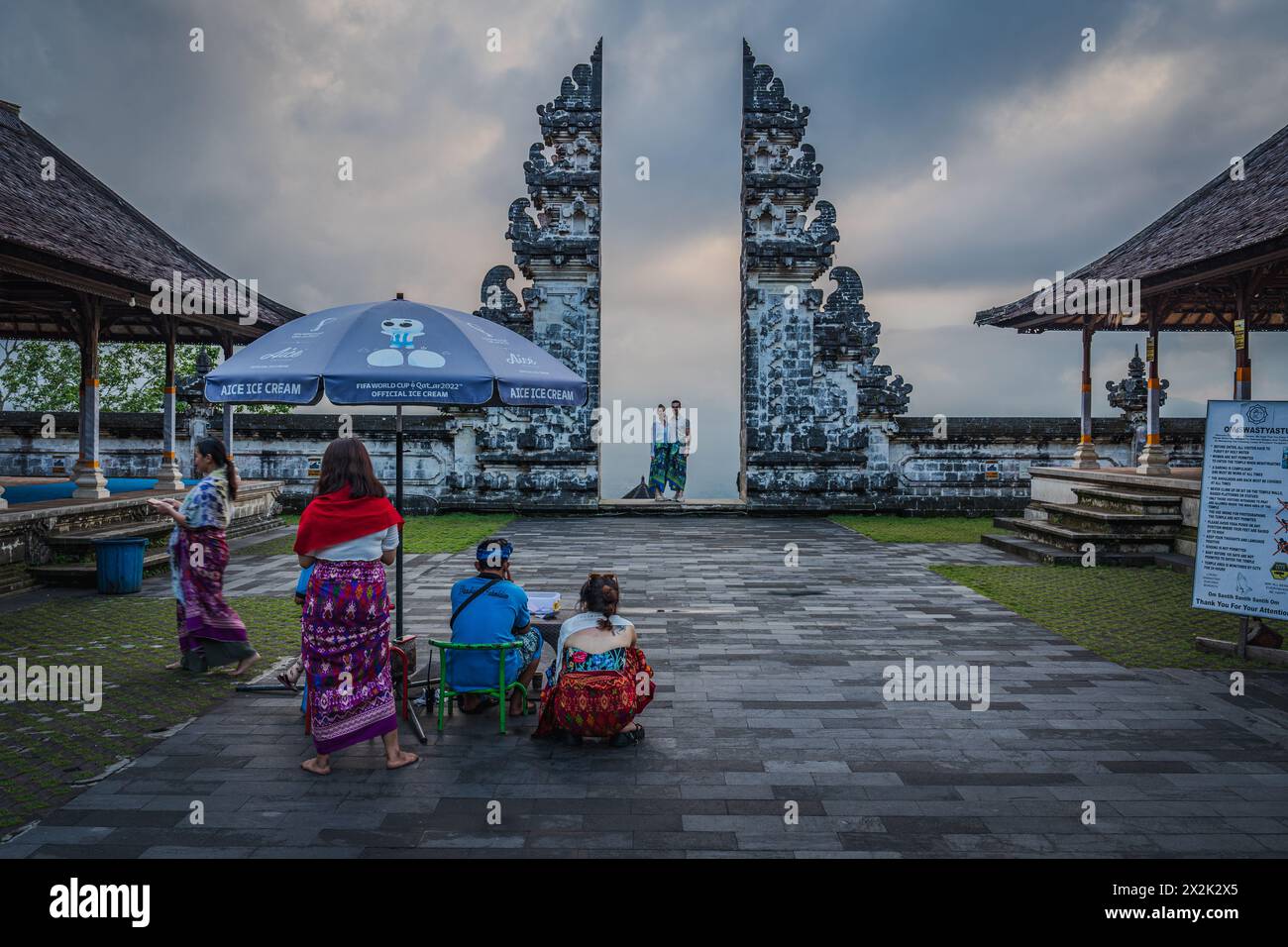 Travelers in traditional sarongs explore an ancient temple in Bali ...