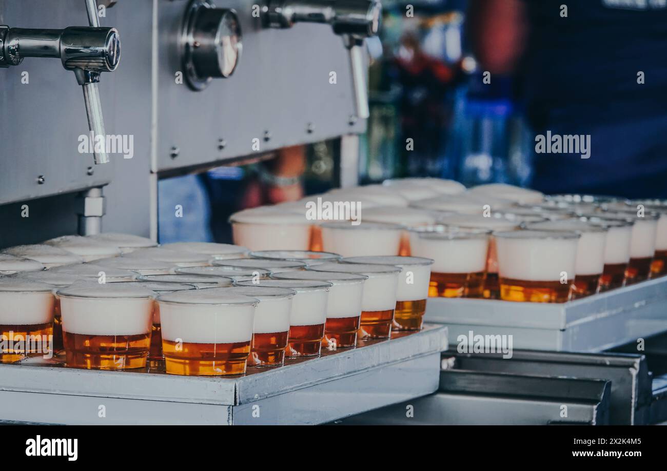View of a beer filling station in a brewery, showcasing multiple cups ...