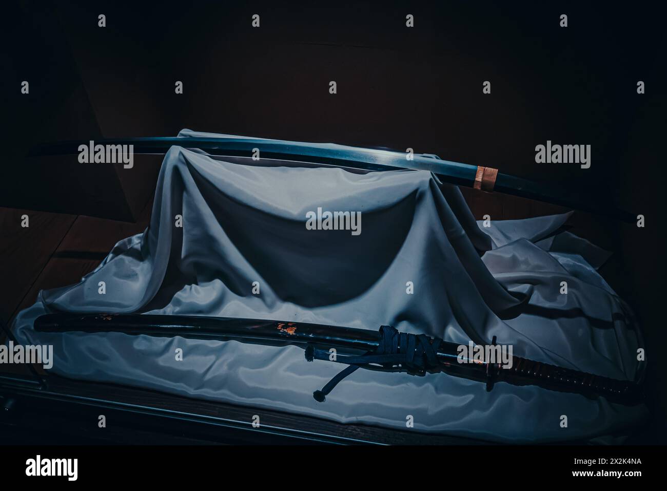 This dark-toned image captures two traditional Japanese katana swords ...