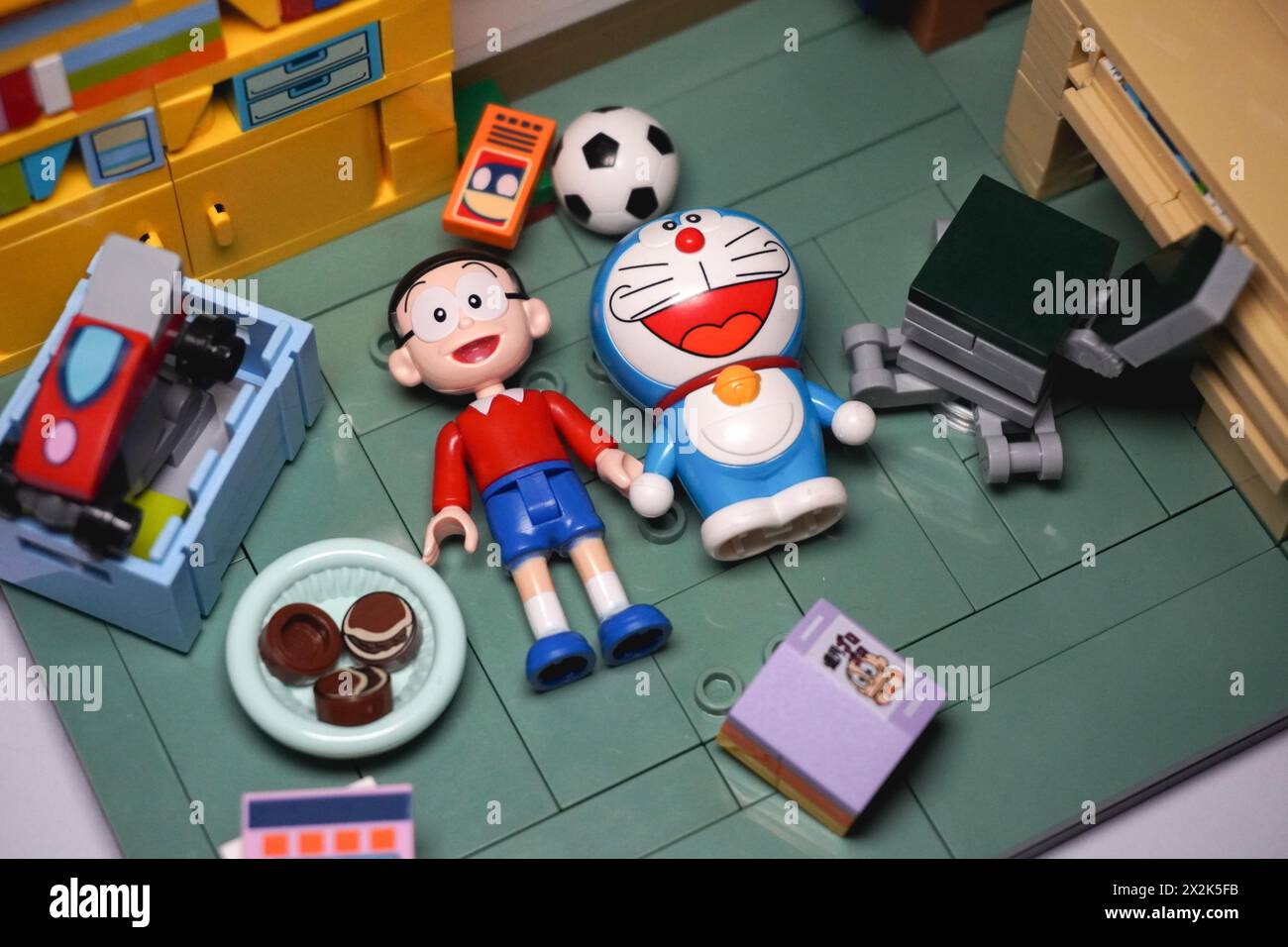 Japanese toy figures, namely Nobita and Doraemon, are lying together on ...
