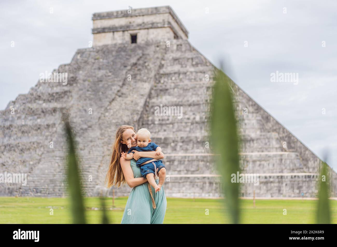 Beautiful tourist woman and her son baby observing the old pyramid and ...
