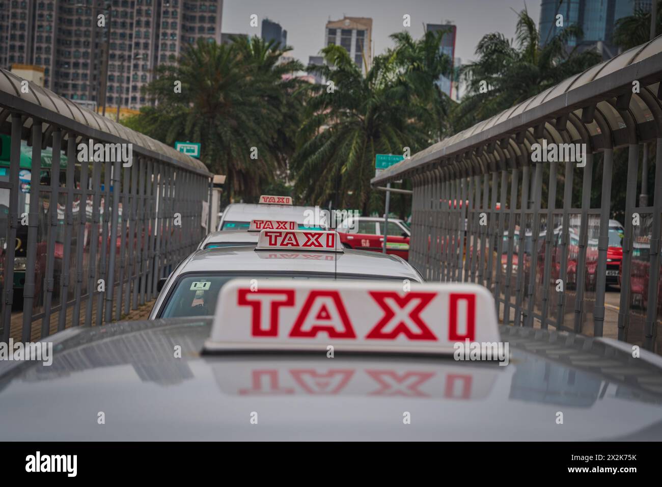 A line of taxis waits at a stand in a bustling cityscape, signaling ...