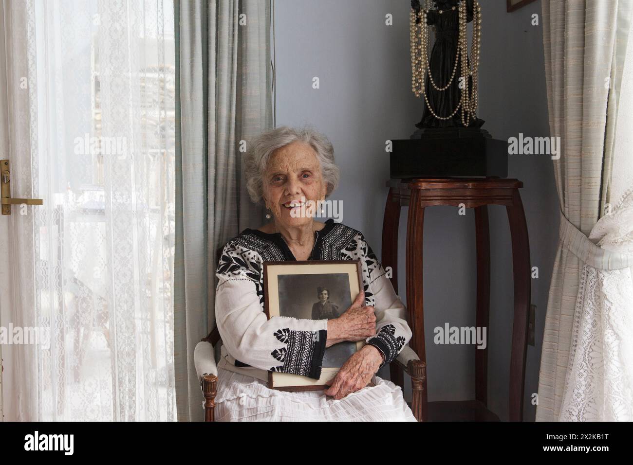 Portrait of Elena Poniatowska at her place holding a photo of her mother photographed during ...