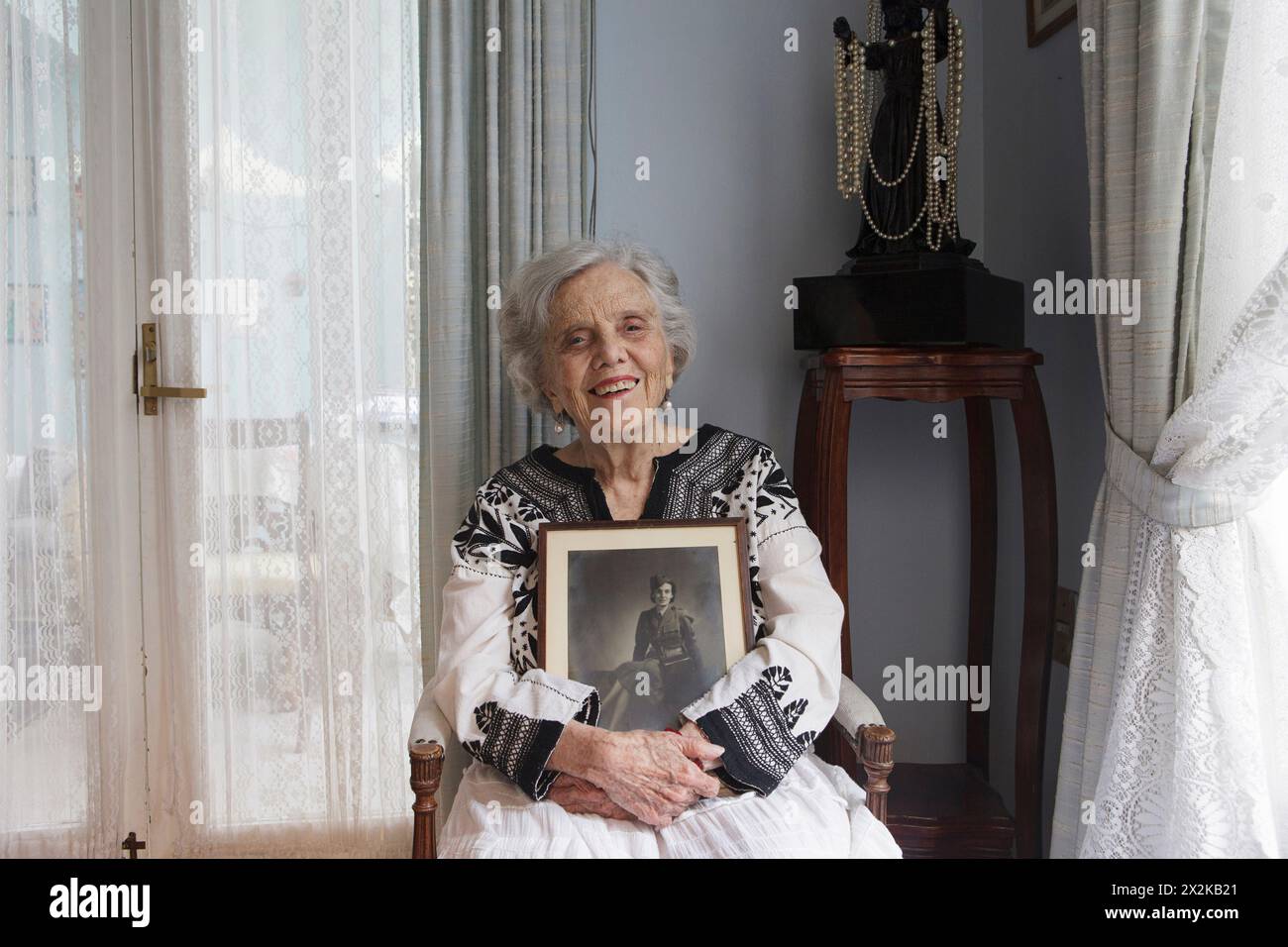 Portrait of Elena Poniatowska at her place holding a photo of her mother photographed during ...