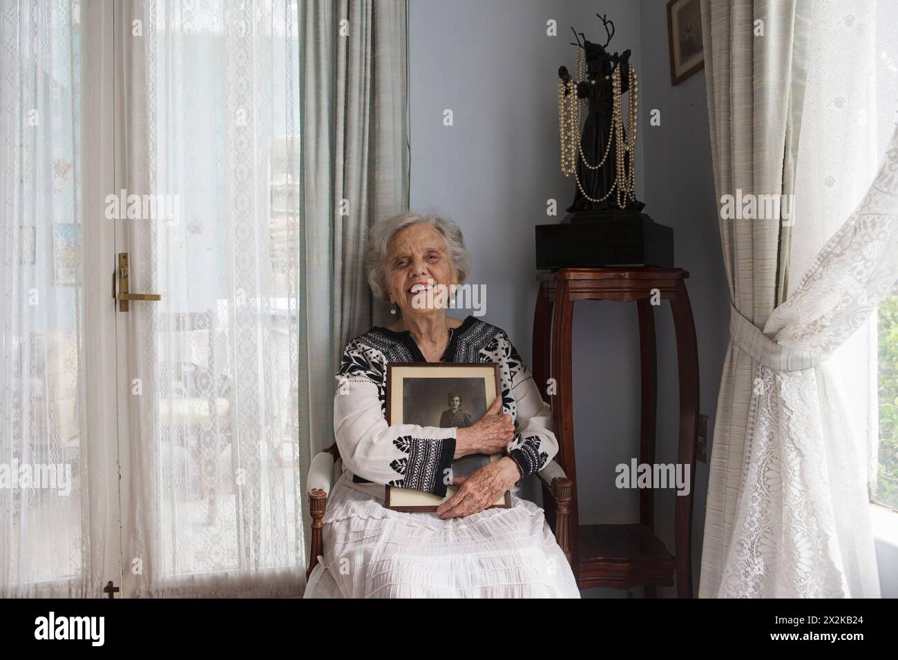 Portrait of Elena Poniatowska at her place holding a photo of her mother photographed during ...