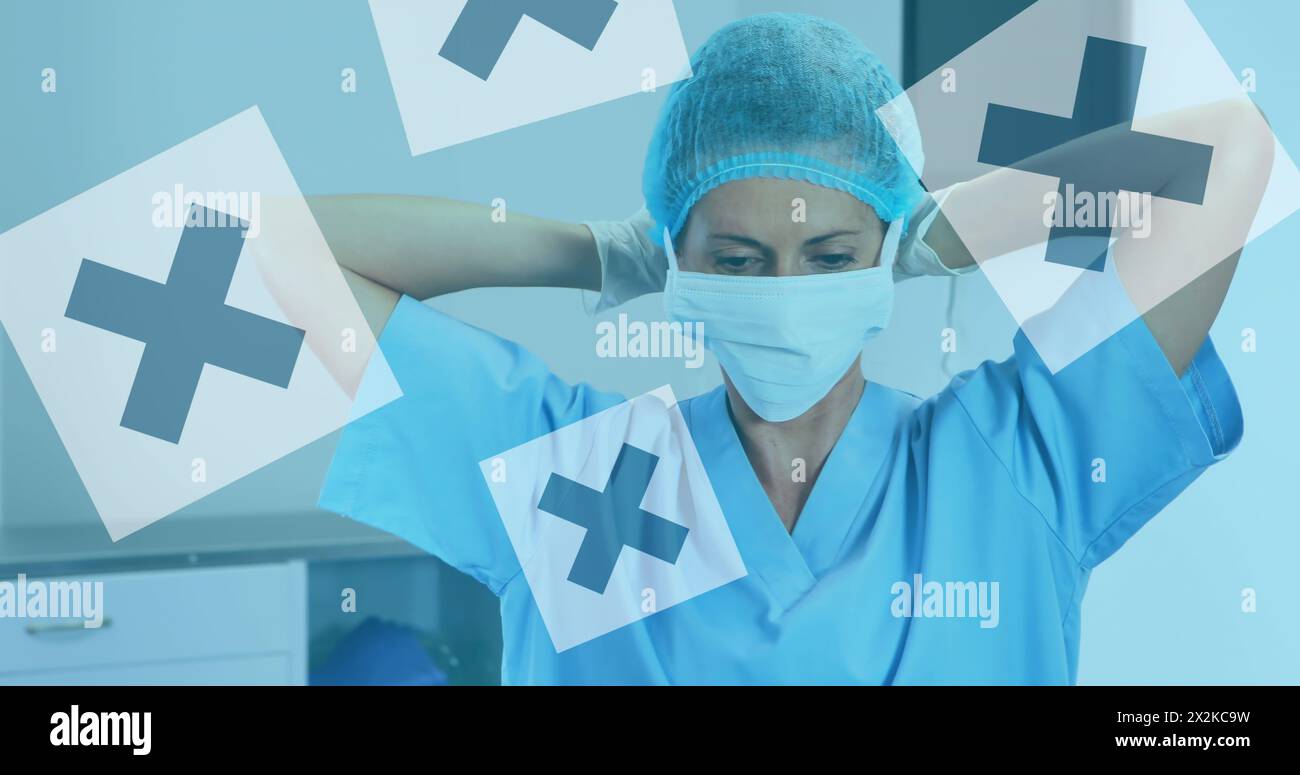 Image of black crosses on white squares over masked female surgeon in ...