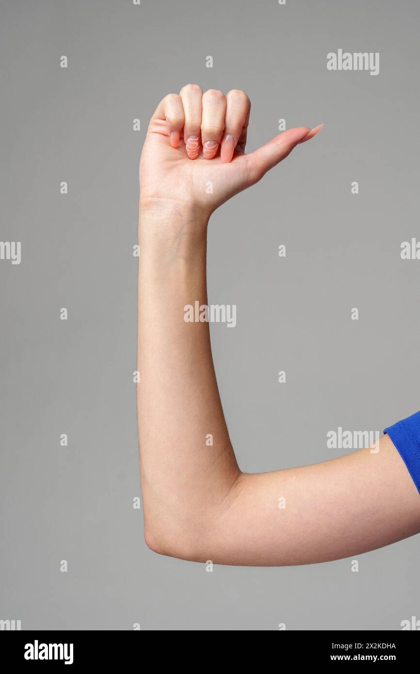 Female hand sign against gray background in studio Stock Photo - Alamy