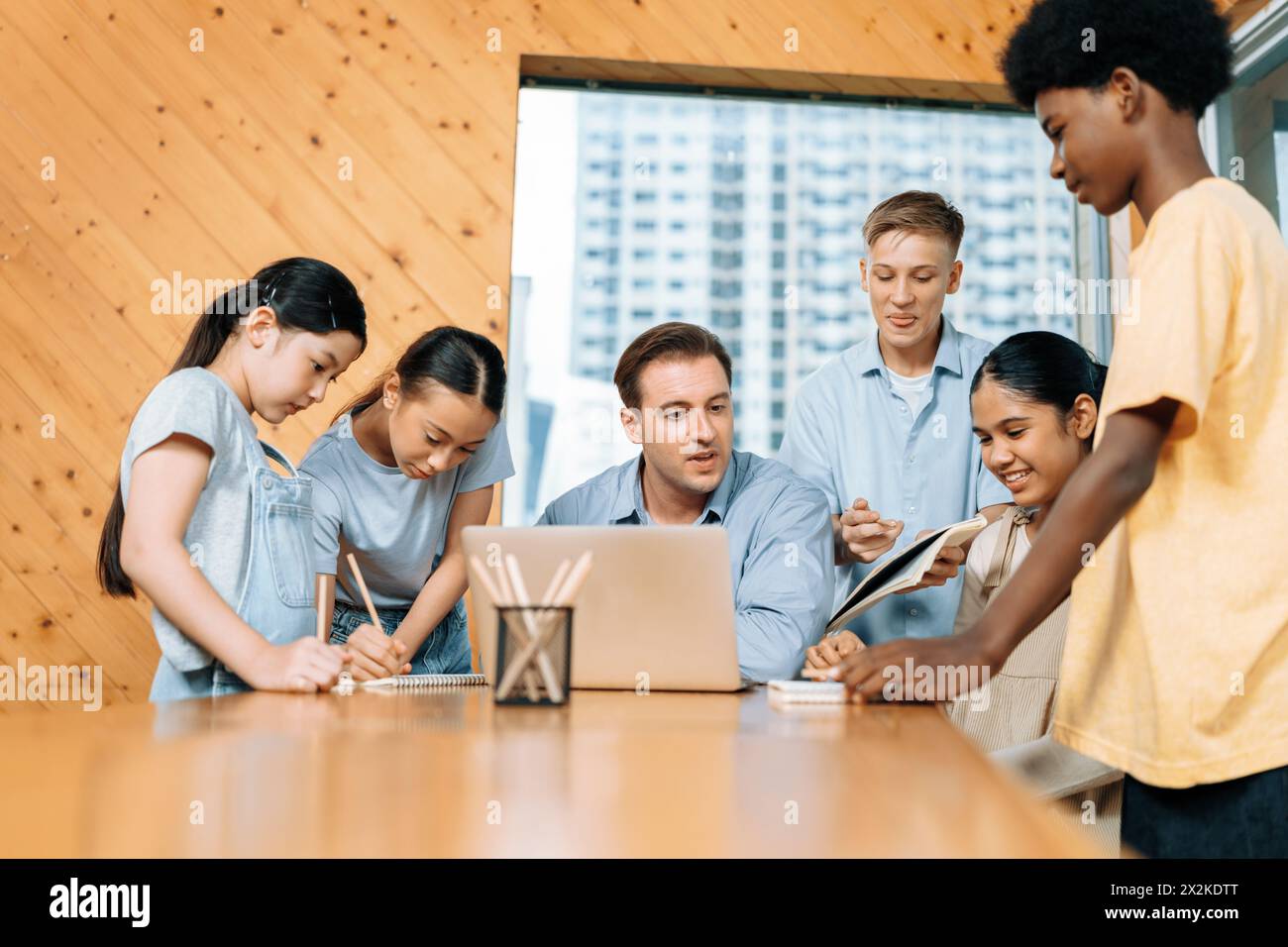 Teacher sitting and giving a lecture on lesson to children in classroom ...