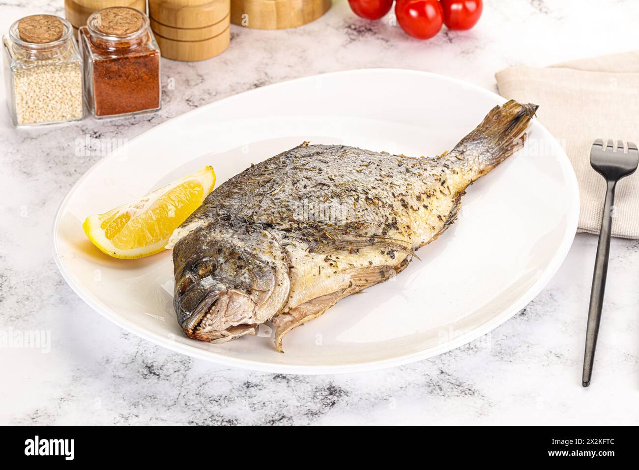 Baked Dorado fish served lemon slice Stock Photo - Alamy