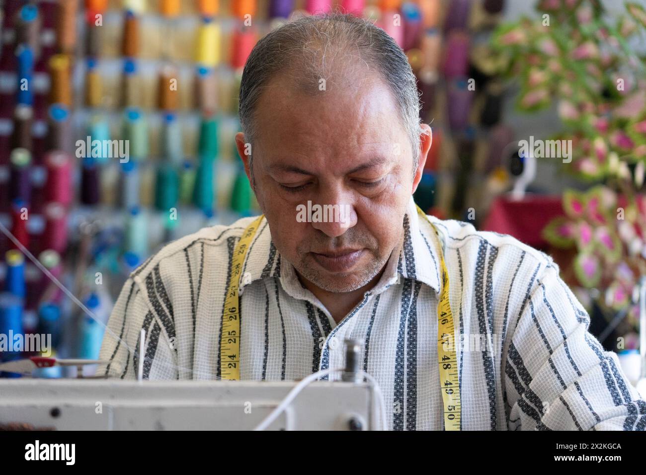Seamstress man sewing on sewing machine Stock Photo - Alamy