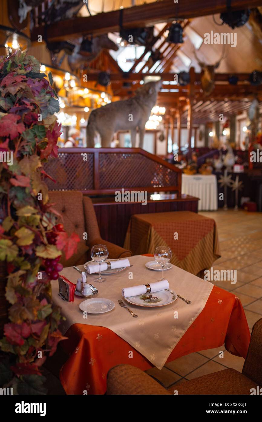 Cozy rustic restaurant interior with table for four, fireplace, hunting ...