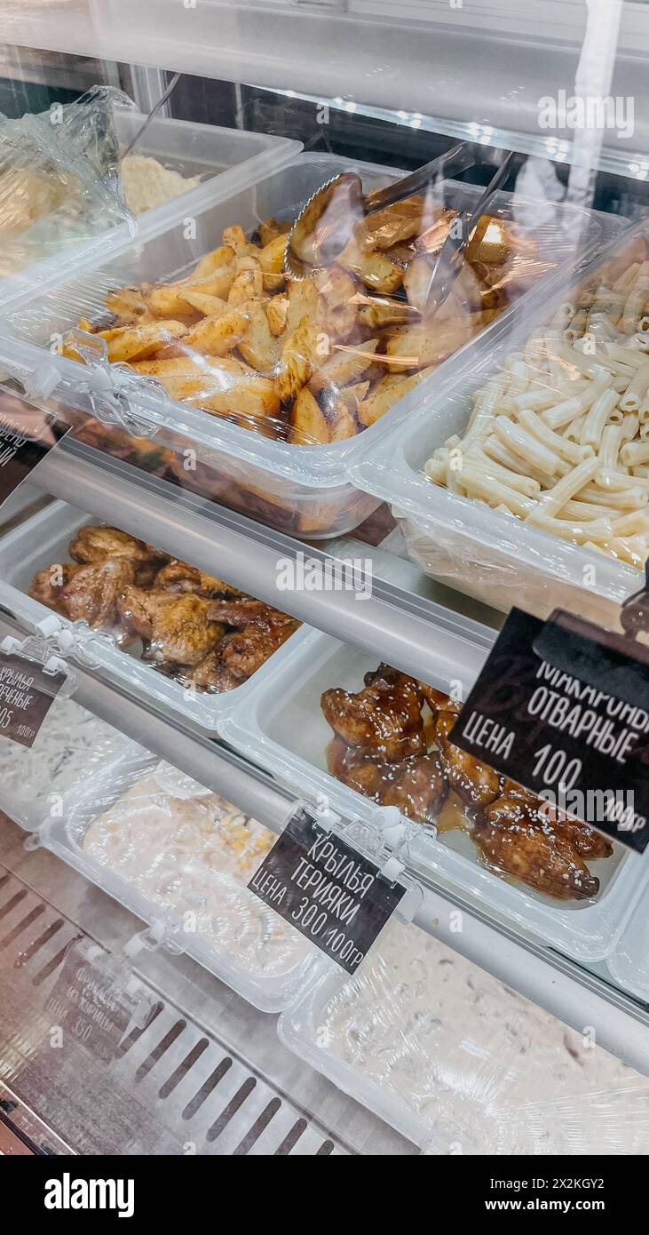 Various delicious food in containers on display in a deli case Stock ...
