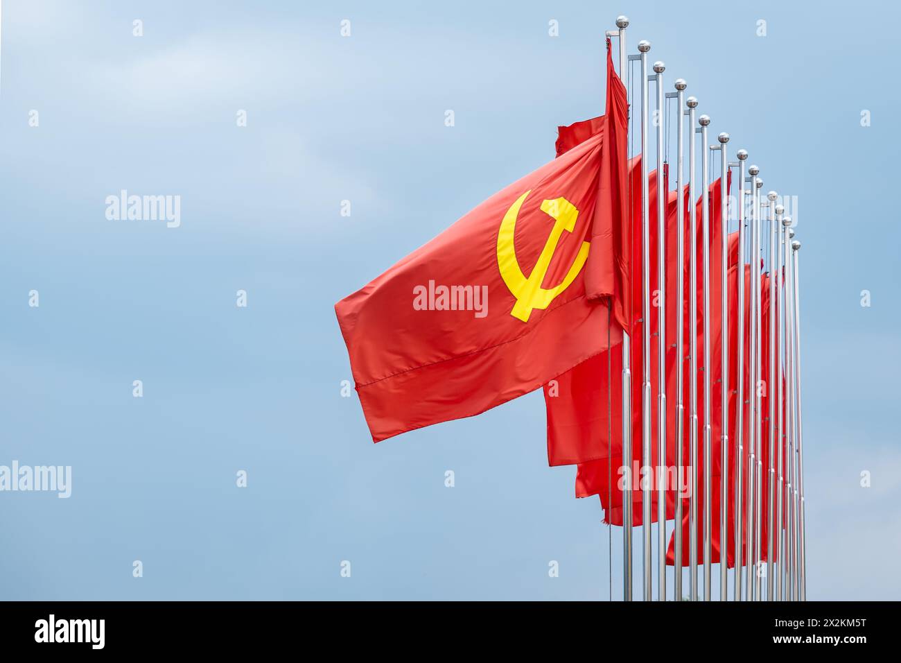 Large communist flag floating in the wind with a blue sky background ...
