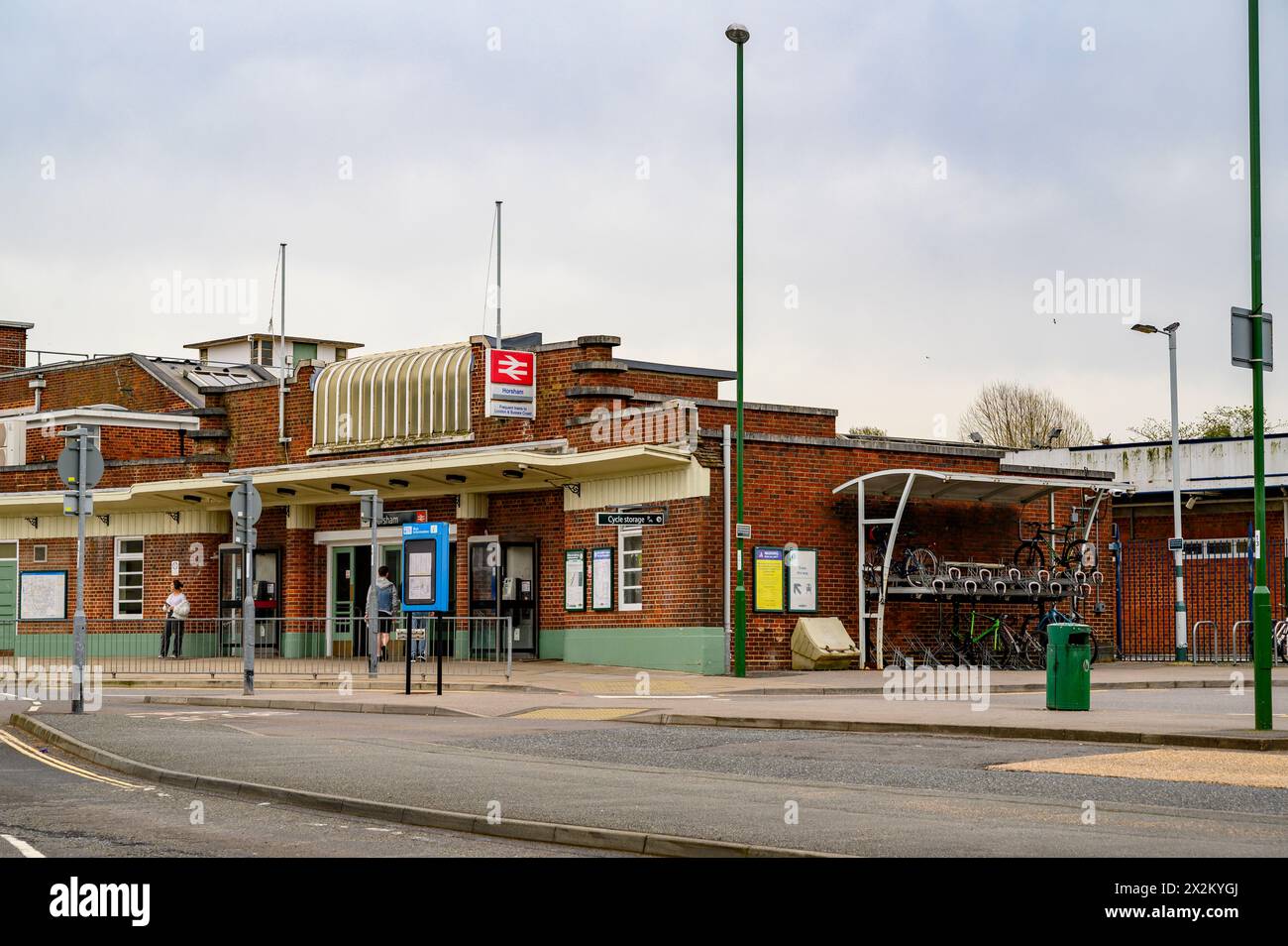 Entrance area of Horsham train station with train lines between London ...