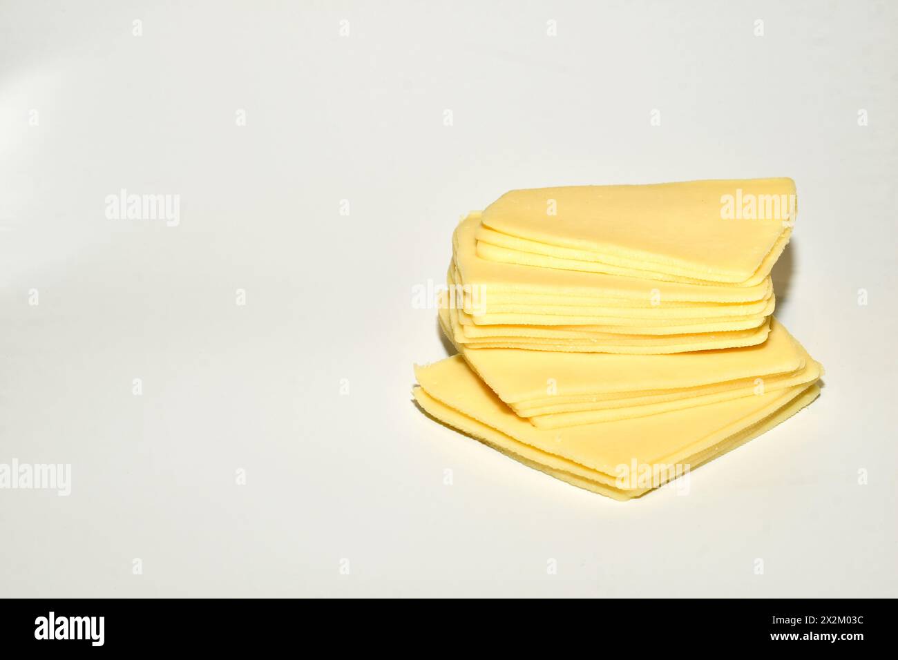 On a white background, a slide of cheese sliced into thin slices Stock ...
