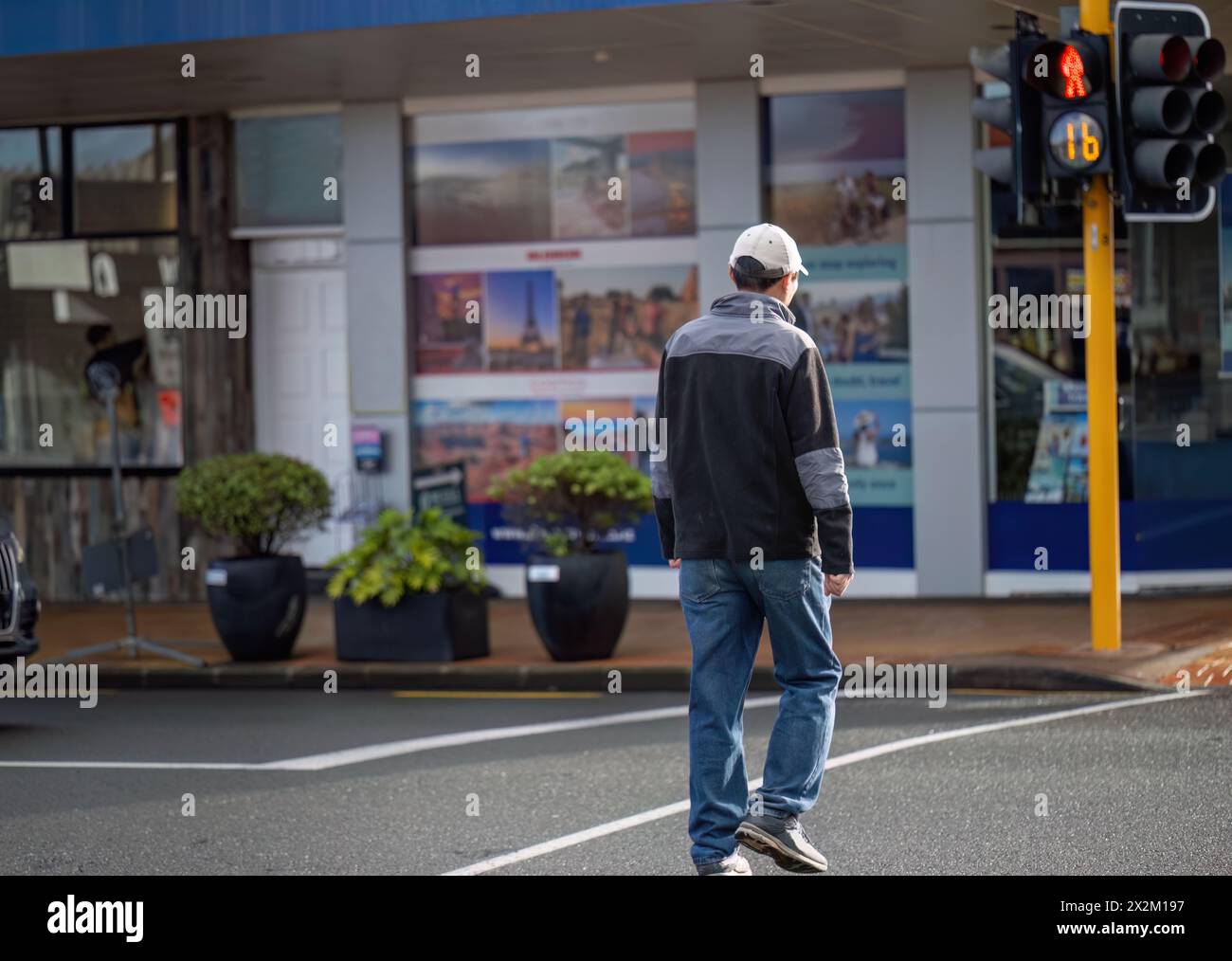 Man walking across the road with pedestrian traffic signal on. Tourism ...