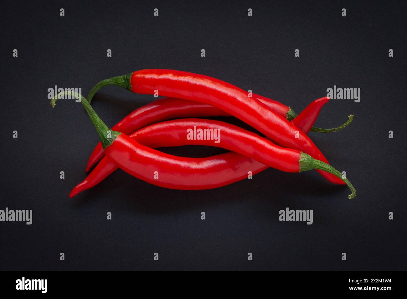Fresh Red Chili Peppers in a pile on black background Stock Photo - Alamy