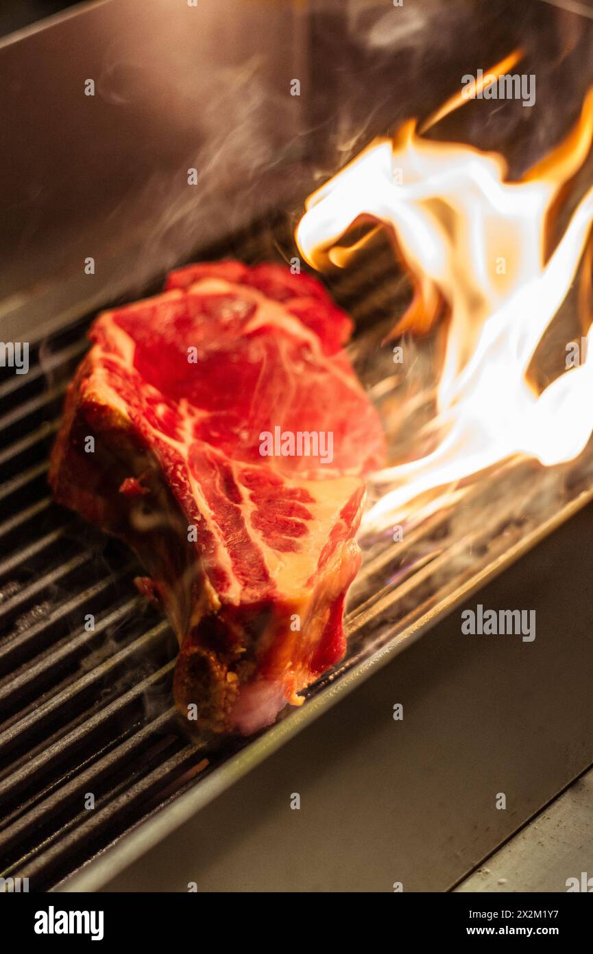 Steak cooking in restaurant kitchen with flames and smoke Stock Photo ...