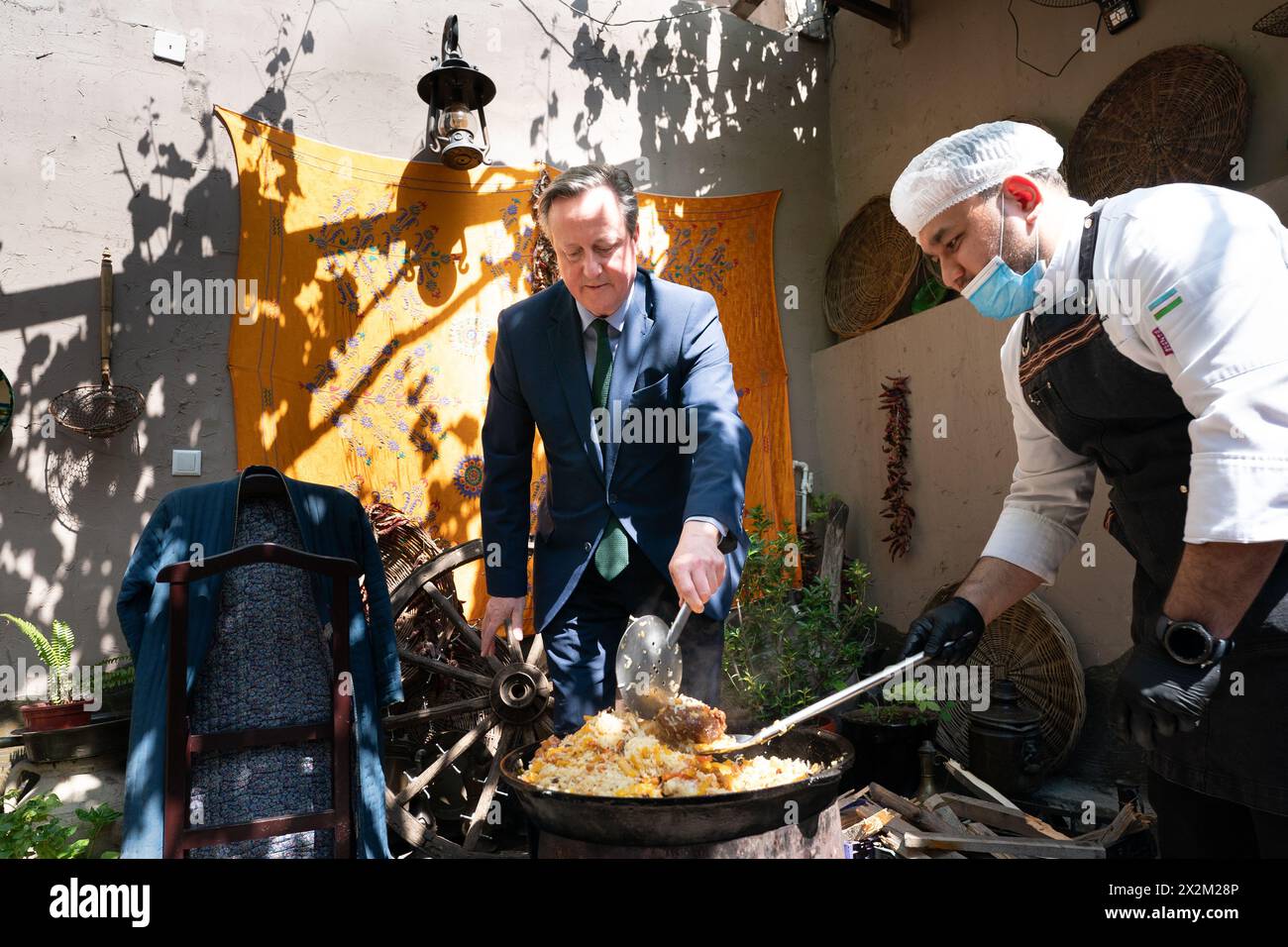 Foreign Secretary Lord David Cameron (left) stirring a pot of Uzbek ...