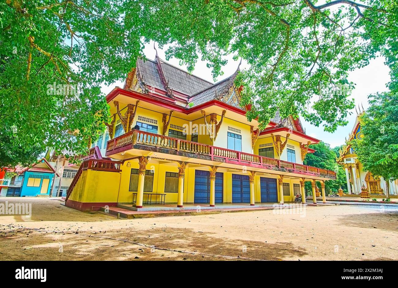 The green courtyard of Wat Suwan Kuha Cave Temple with tall spread ...
