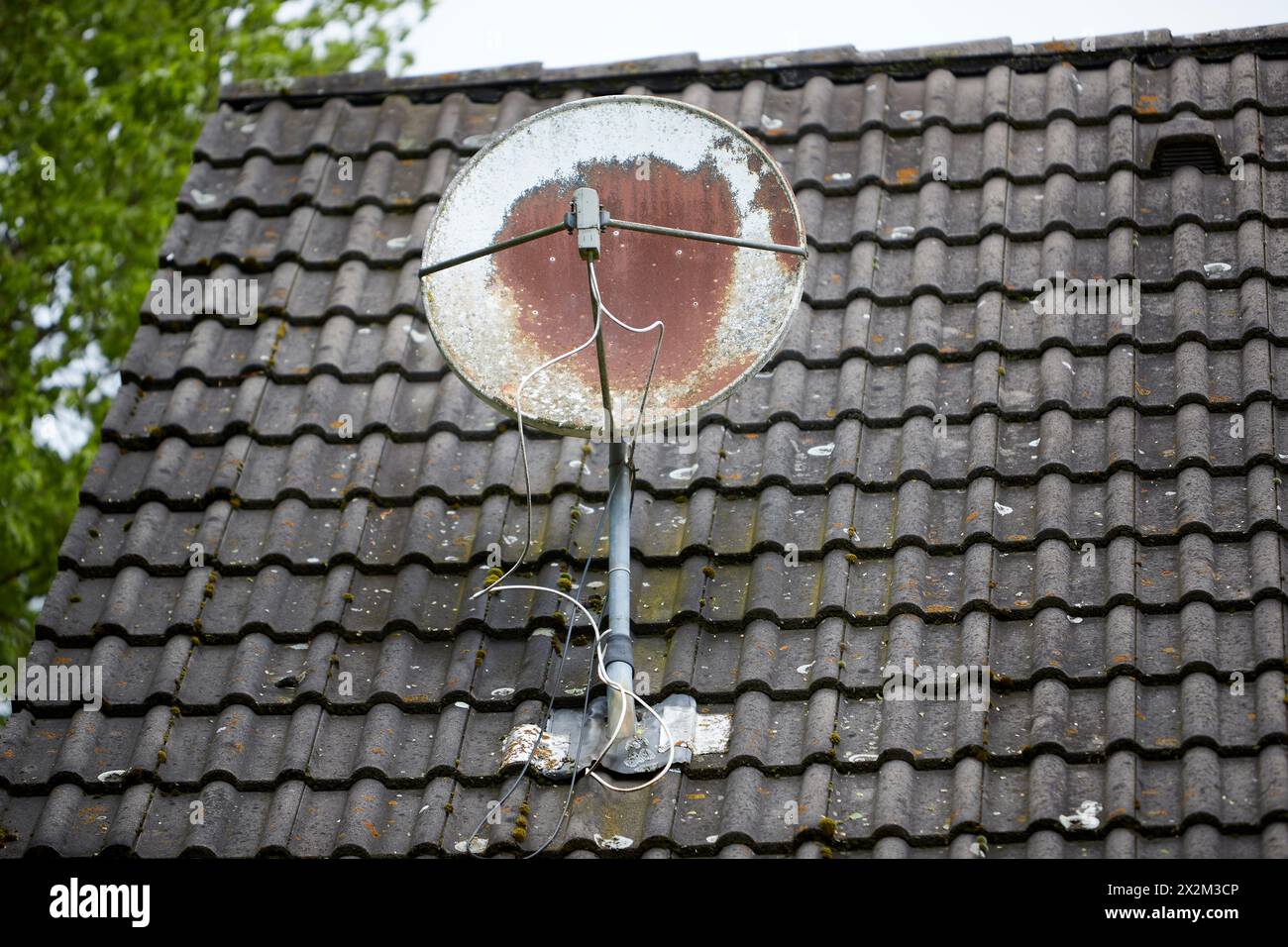 old rusty satellite dish on a house roof Stock Photo - Alamy