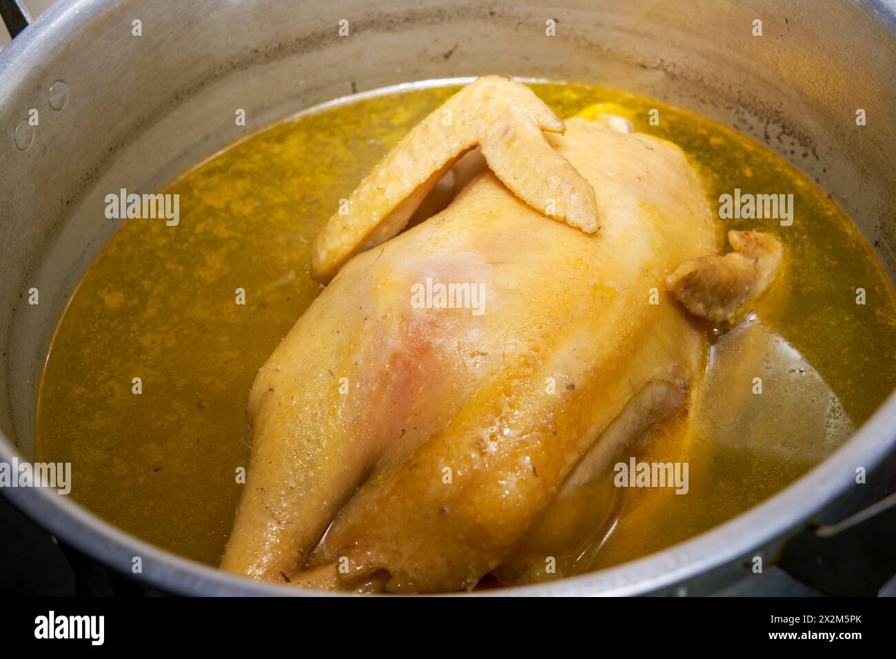 A plump Cantonese white-cut chicken being cooked in the pot Stock Photo ...