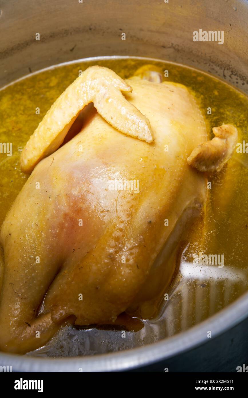 A plump Cantonese white-cut chicken being cooked in the pot Stock Photo ...