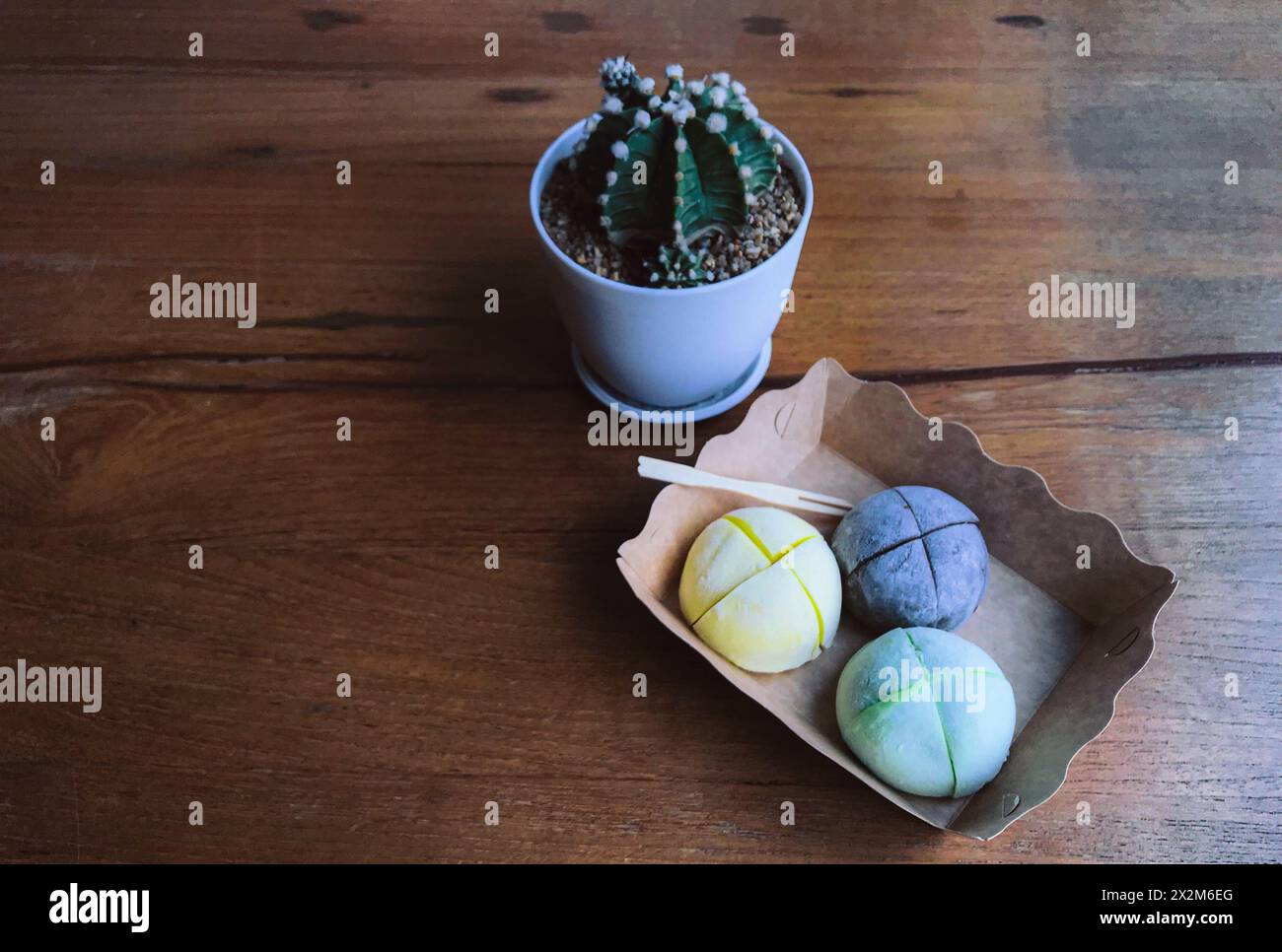Japanese ice cream Mochi on a brown-paper plate on a wooden table with ...