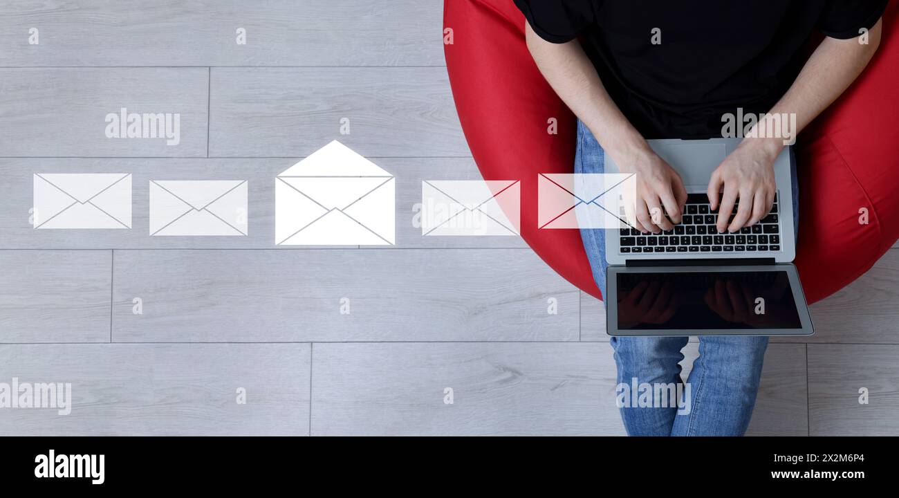 Email. Man using laptop indoors, top view. Letter illustrations over ...