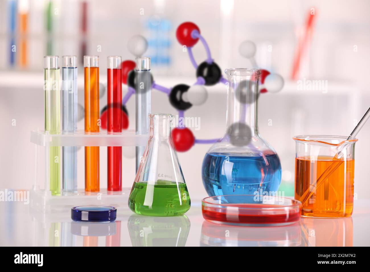 Different glassware and molecule model in laboratory Stock Photo - Alamy