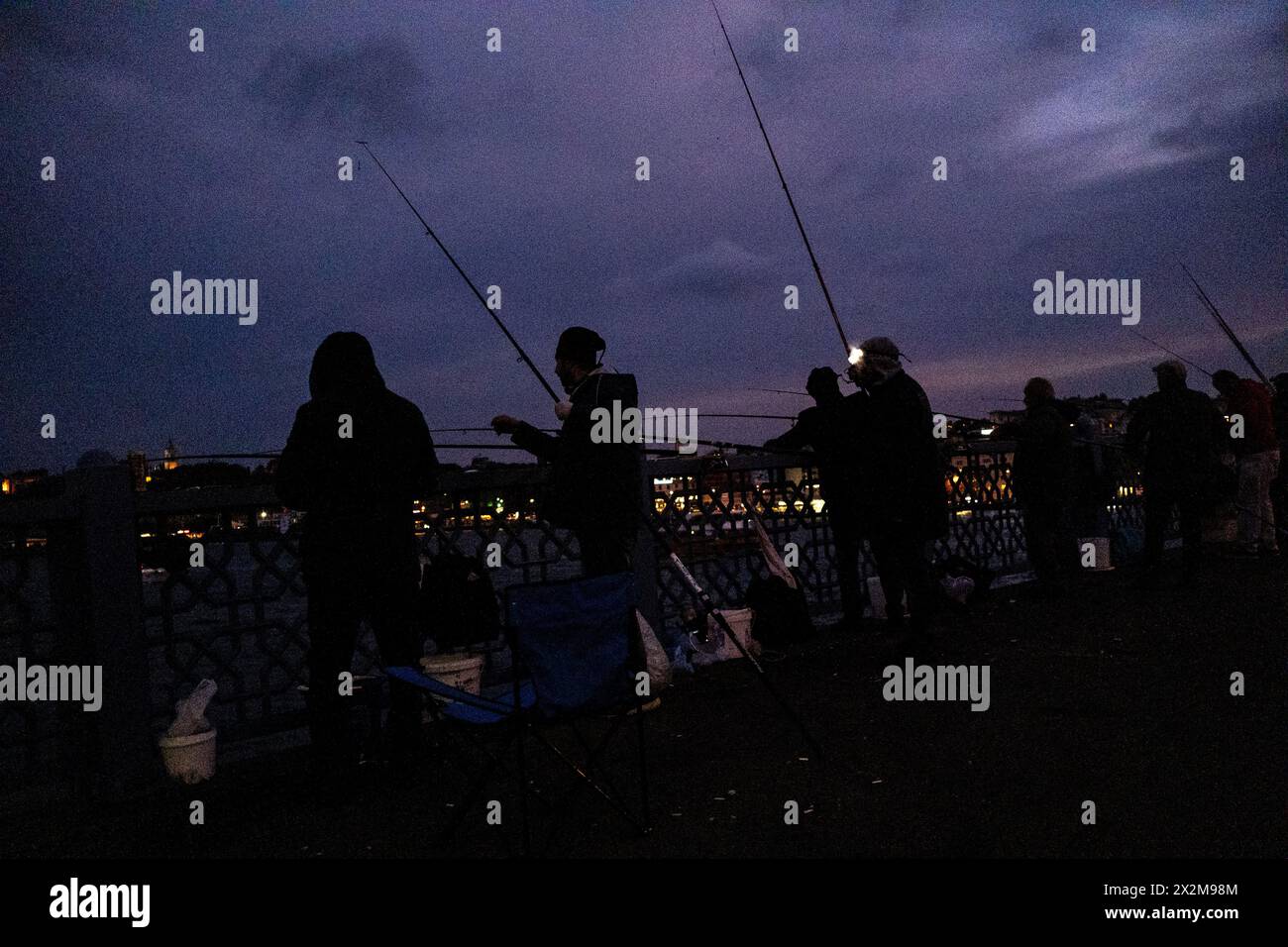 Fishermen on the Galata Bridge on the Golden Horn estuary at dusk ...