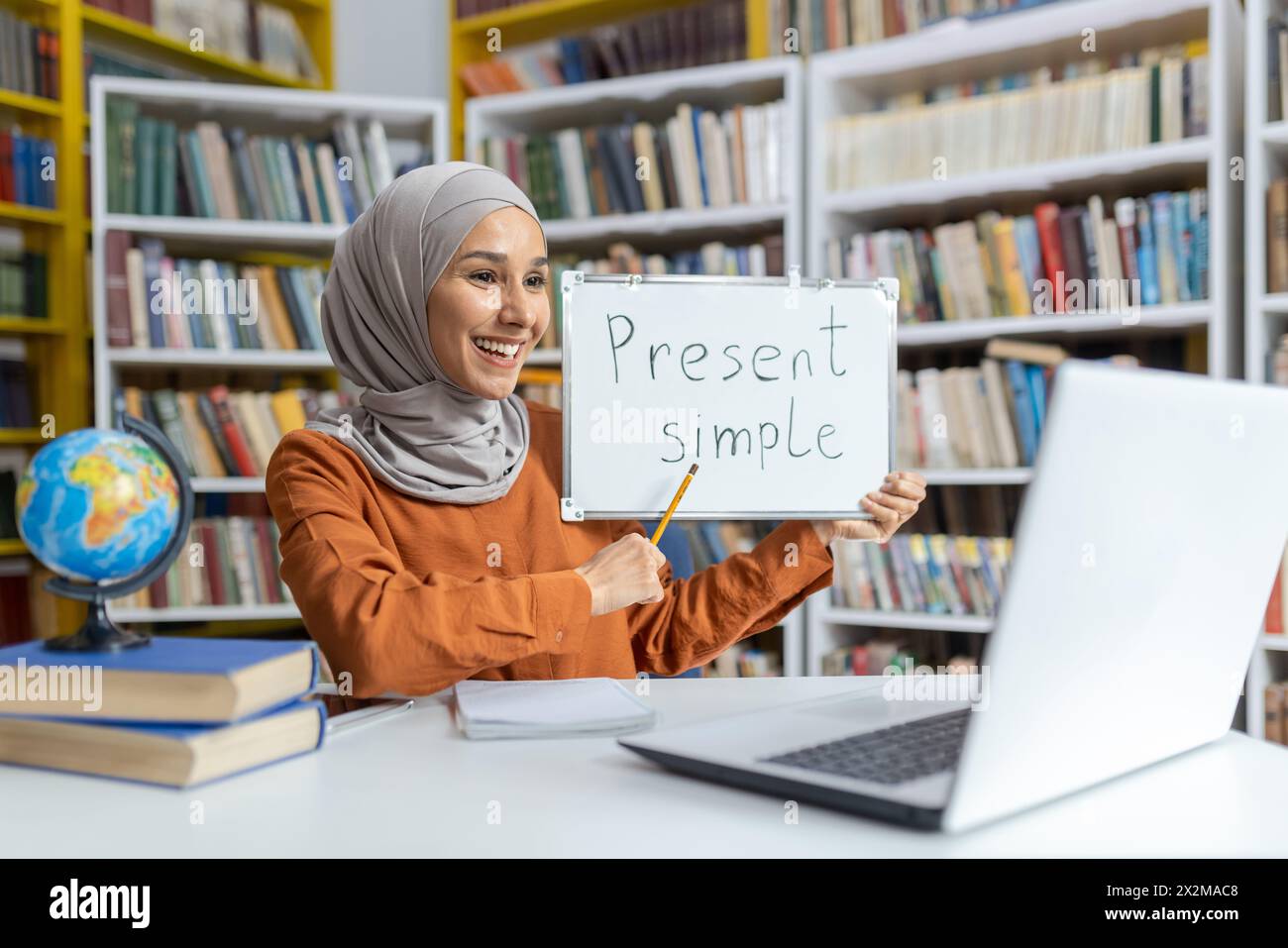 A cheerful Muslim woman in hijab demonstrates English grammar, using ...