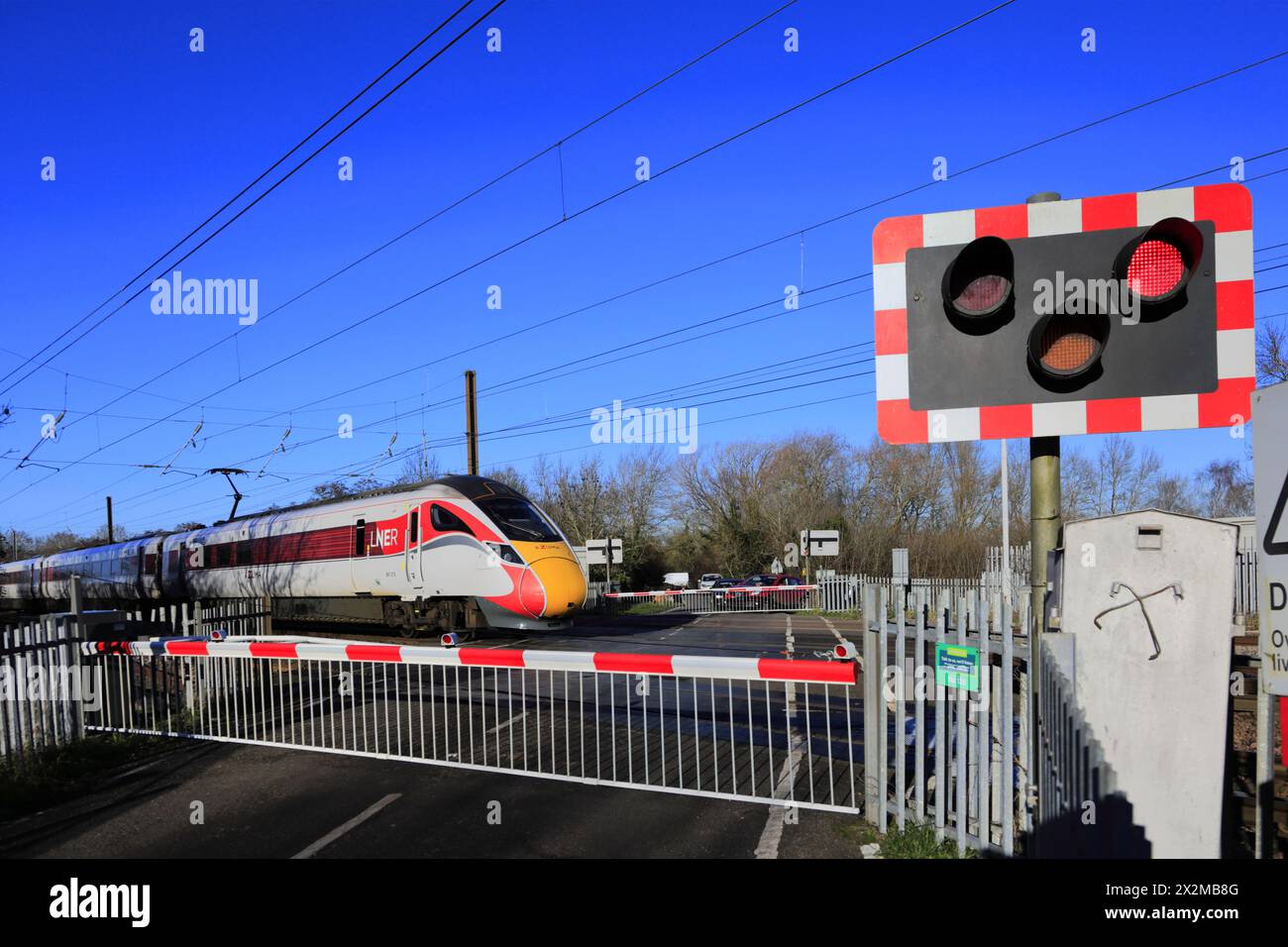 An Azuma train passing red lights at an Lolham unmanned Level crossing ...