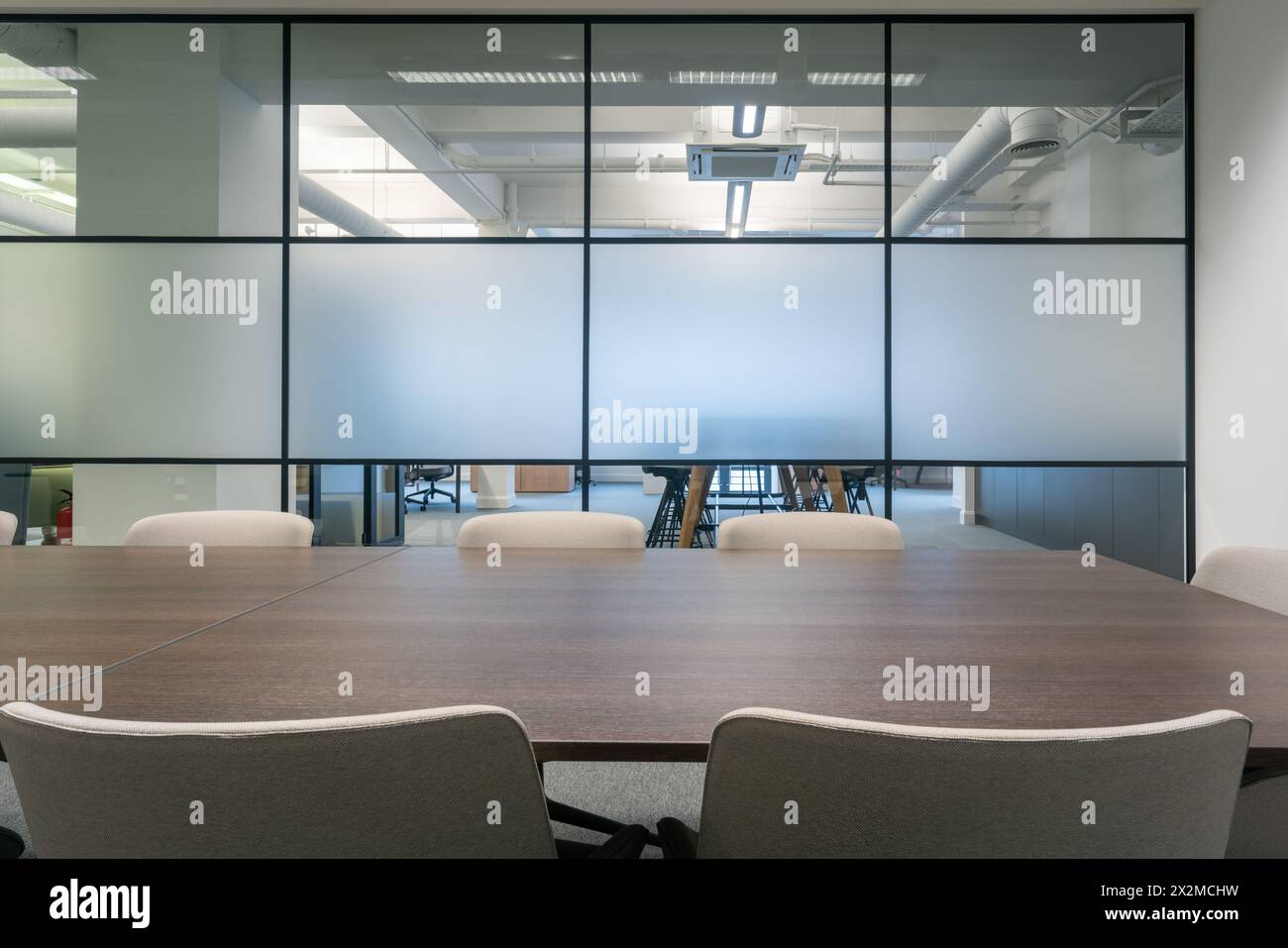 A sleek, contemporary office conference room featuring a large wooden ...