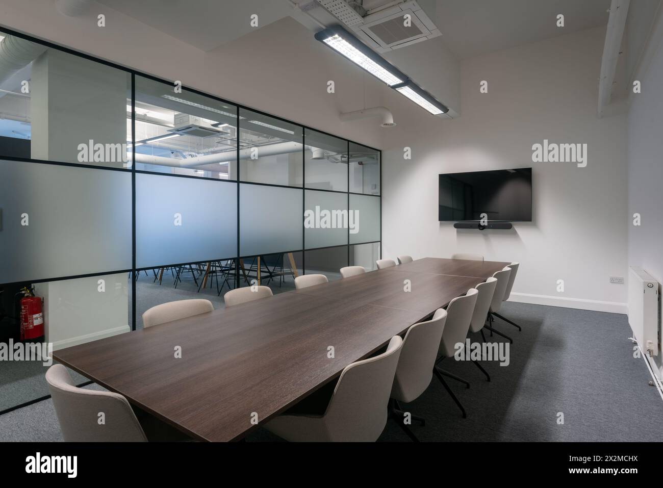 A contemporary office conference room featuring a long table with ...