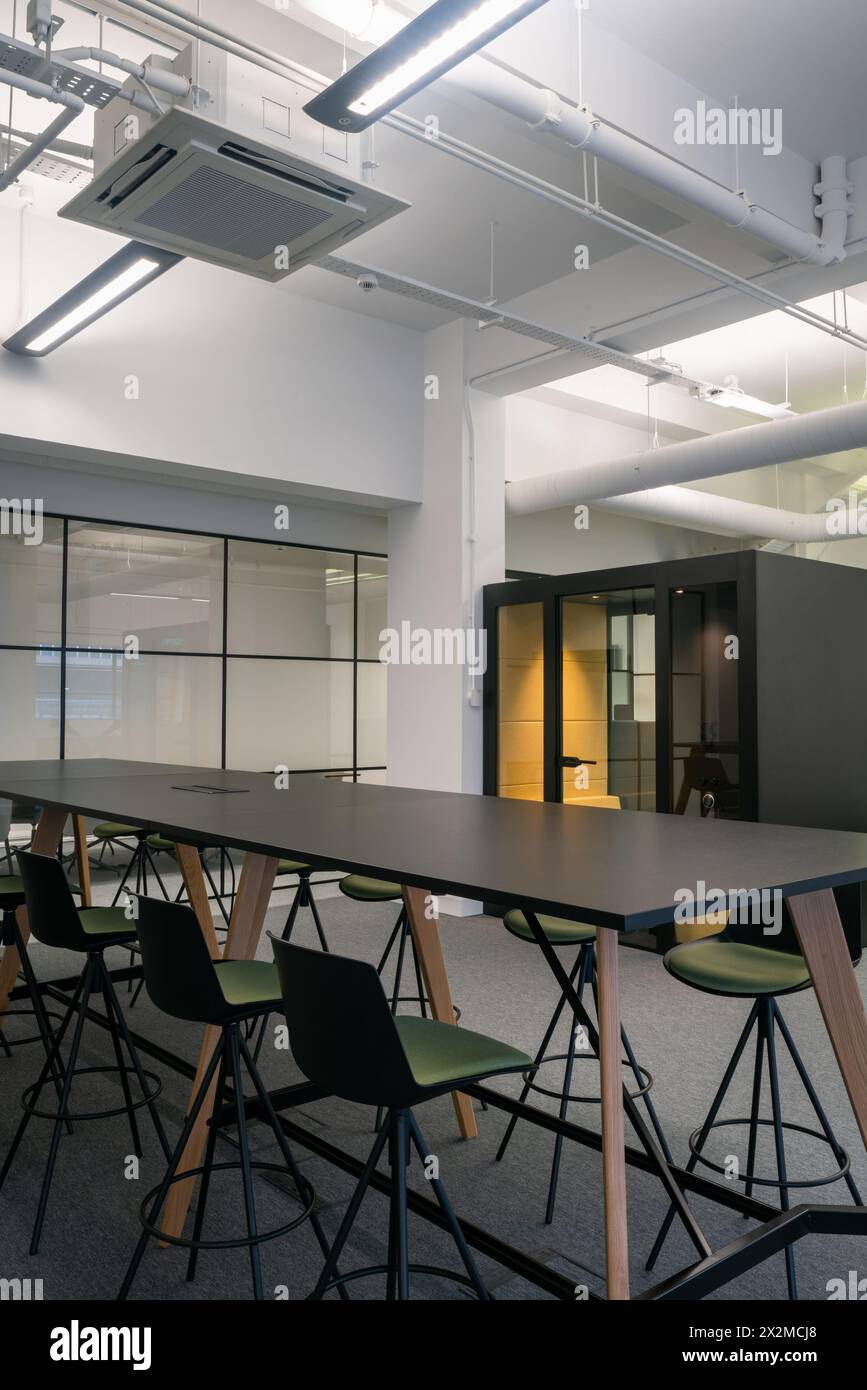 A sleek, contemporary office space, featuring a long conference table ...