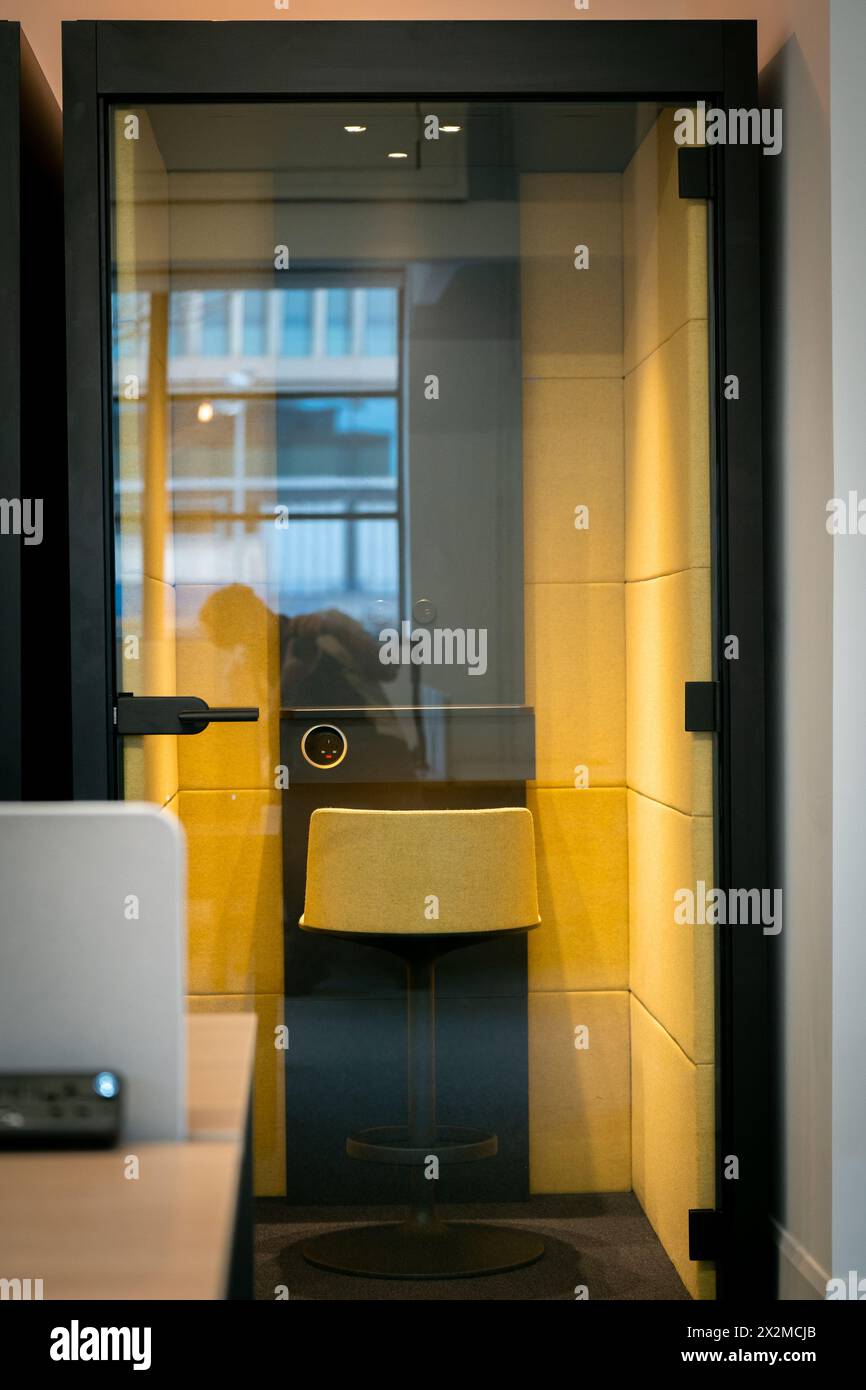 View of a contemporary office phone booth with a single yellow chair ...