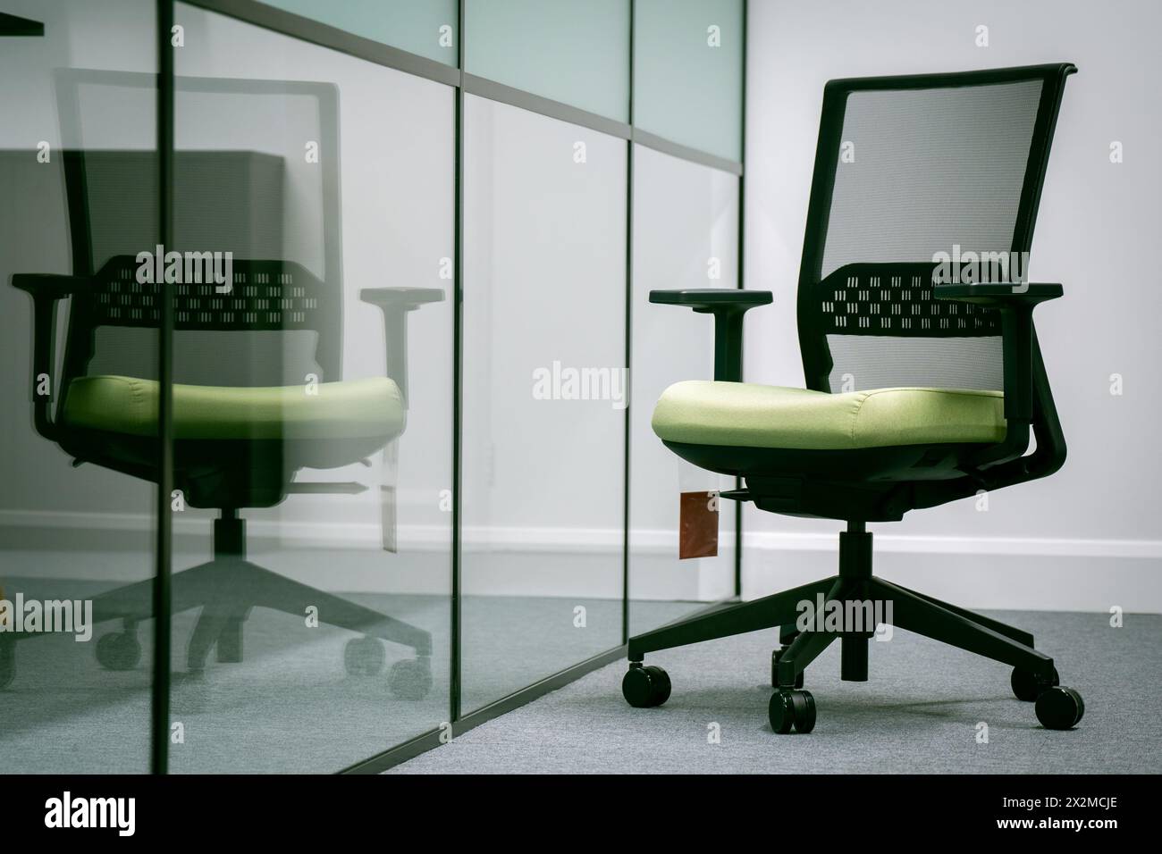 A sleek black office chair with a lime green seat cushion isolated ...