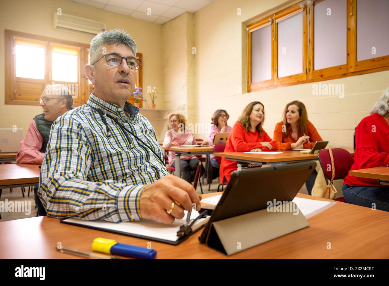 Mature adults engaged in a learning session in a classroom environment ...