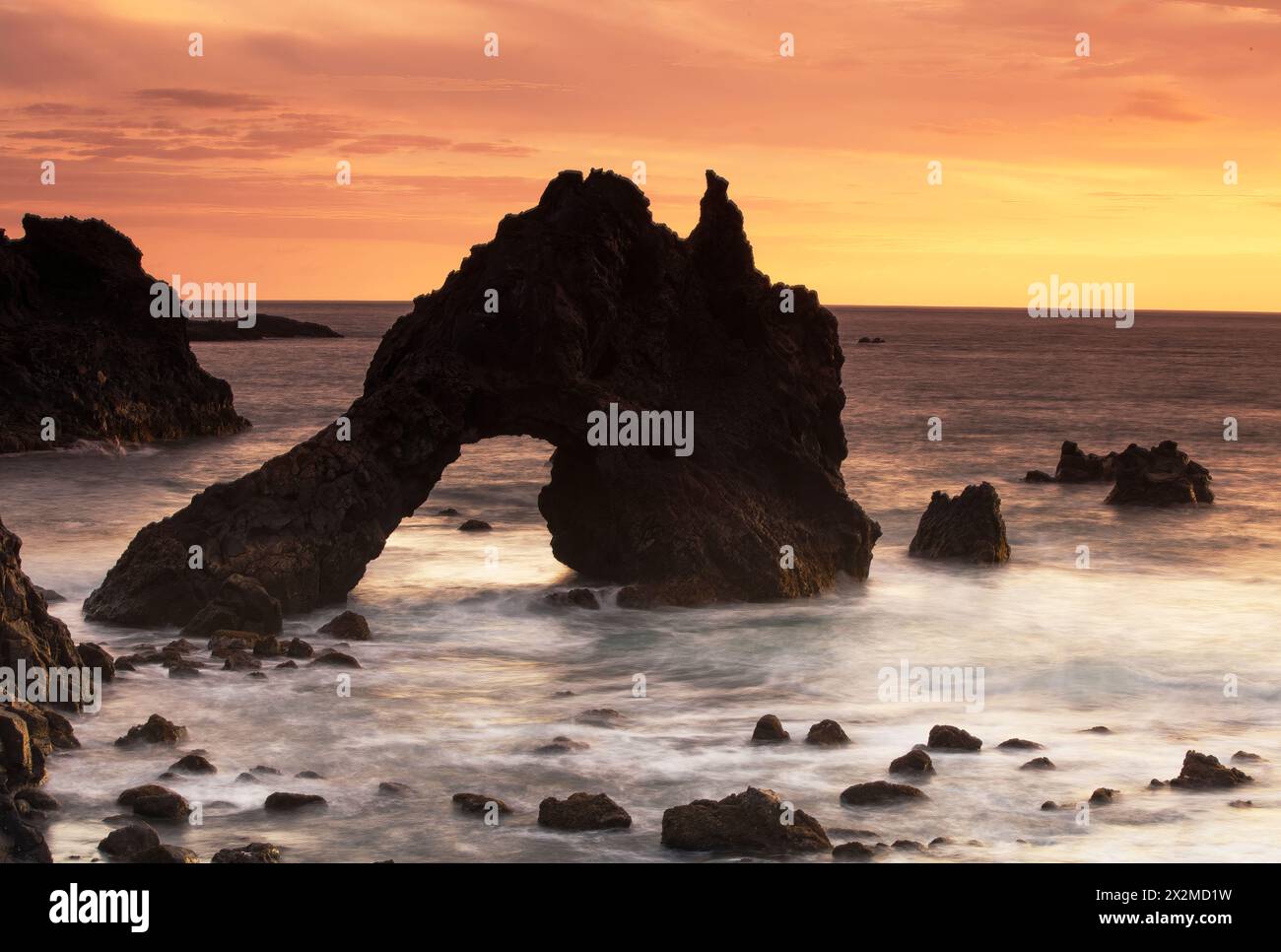 Dramatic rock formations create a natural arch at Playa de los Roques ...