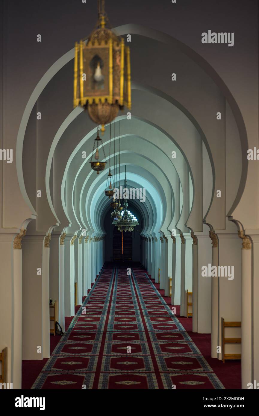 Serene symmetrical view of an arched corridor inside a Moroccan mosque ...