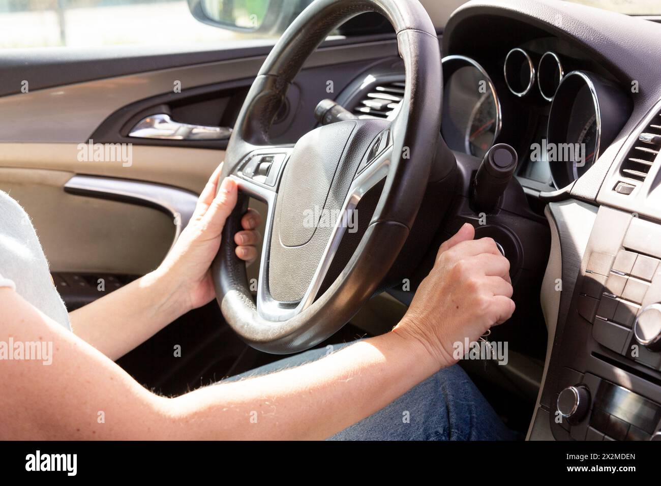 Close-up view of the hands of a person using the steering wheel and ...