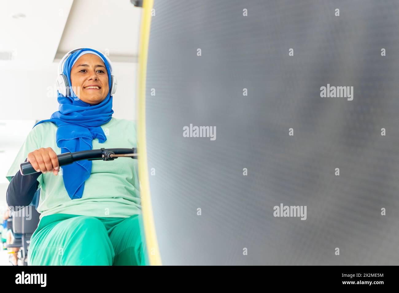 An Arabian woman in traditional hijab and sporting attire works out at ...
