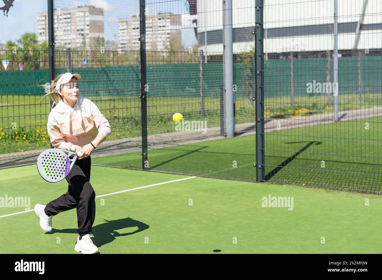 Young sporty woman performing basic strokes during paddle tennis group ...