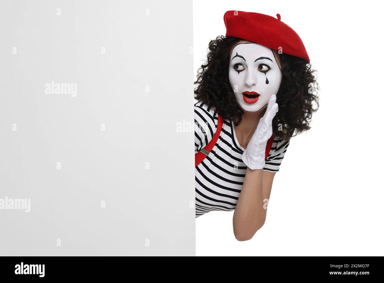 Funny mime with blank poster posing on white background Stock Photo - Alamy