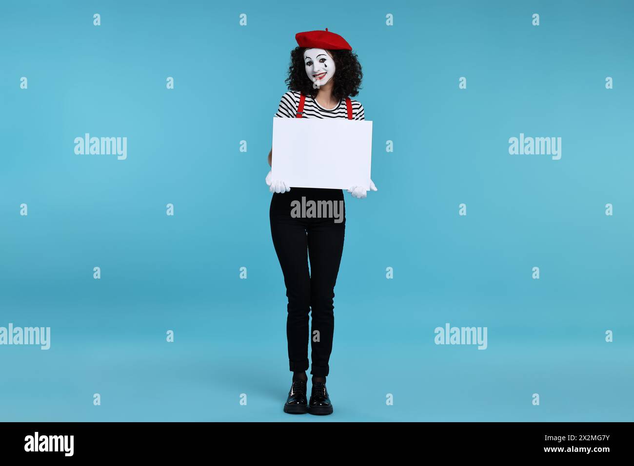 Funny mime with blank sign posing on light blue background Stock Photo ...